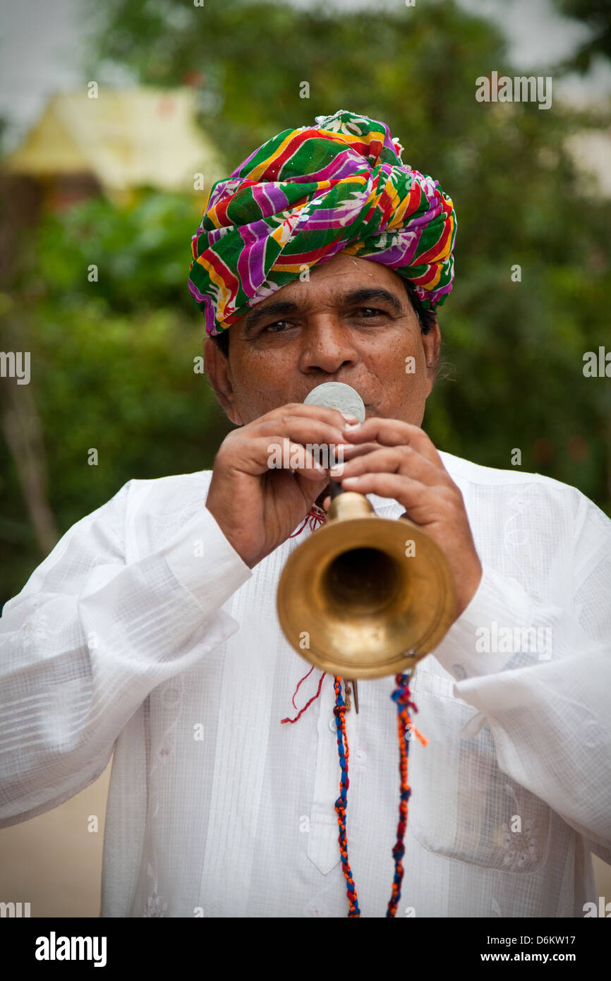 An Indian man plays the trumpet as part of a welcome ceremony in ...
