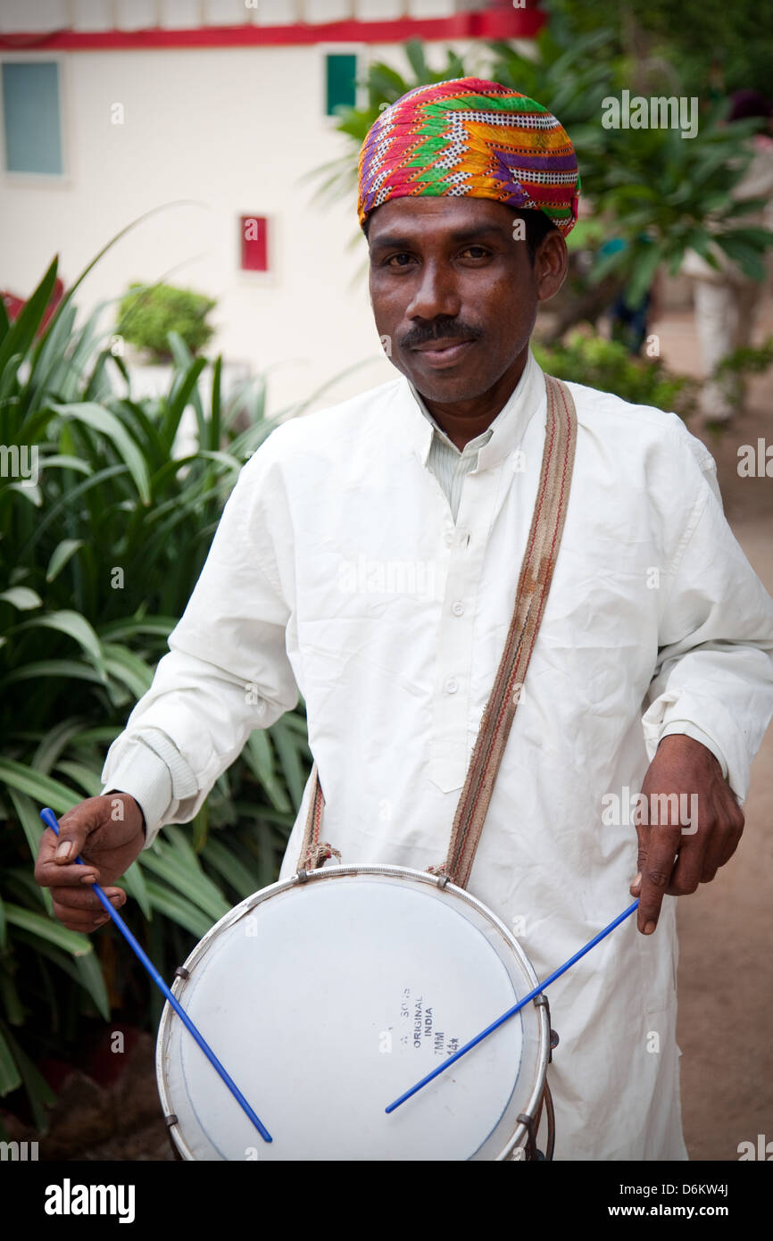 An Indian man plays the drum as part of a welcome ceremony in Balasinor ...