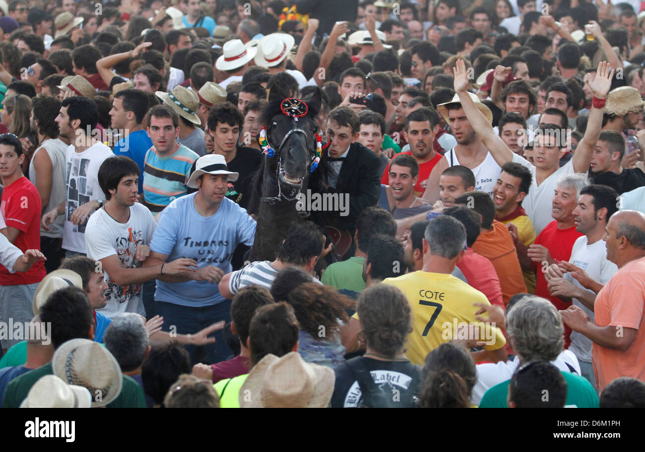 A rider rears up on his horse surrounded by a cheering crowd in ...