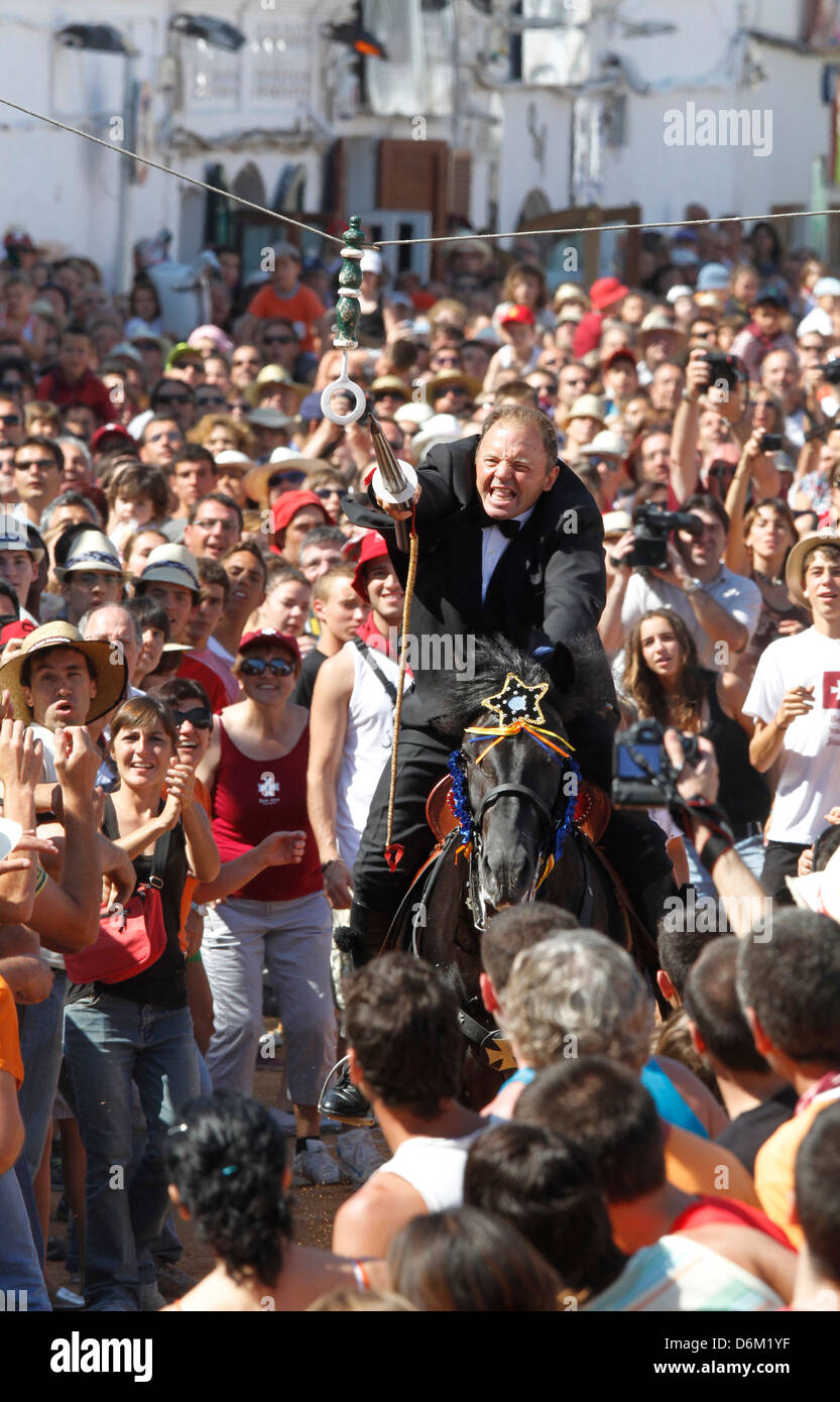 A rider prepares to spear a suspended ring with a lance as he races ...