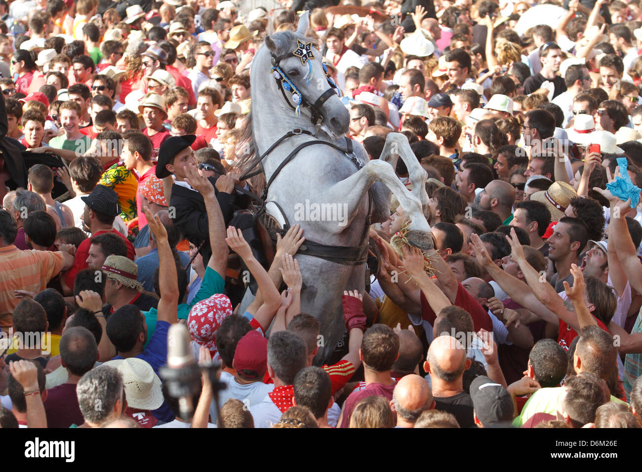 A rider rears up on his horse surrounded by a cheering crowd in ...