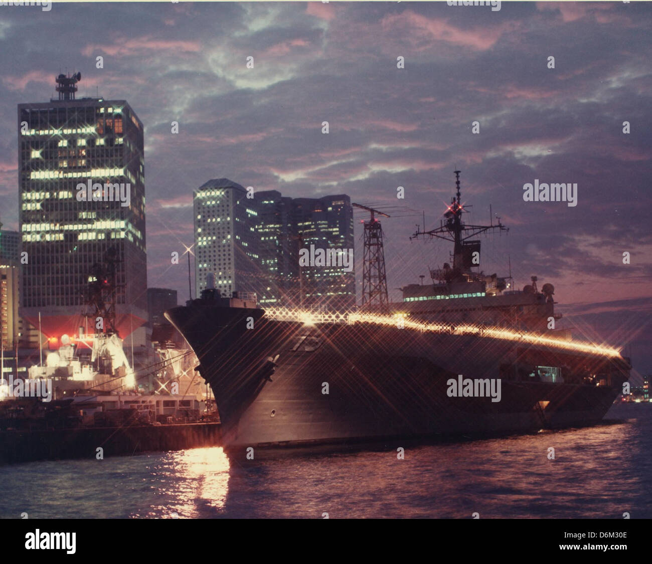 This image depicts a ship in a harbor at night, captured by the Naval ...