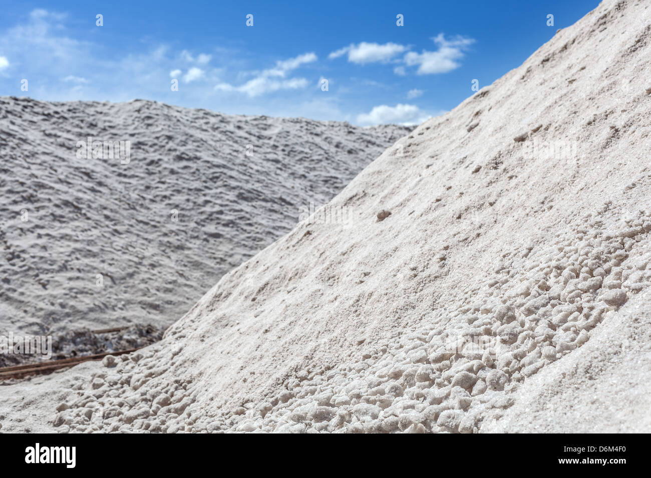 Big pile of freshly mined salt, set against a blue sky Stock Photo - Alamy