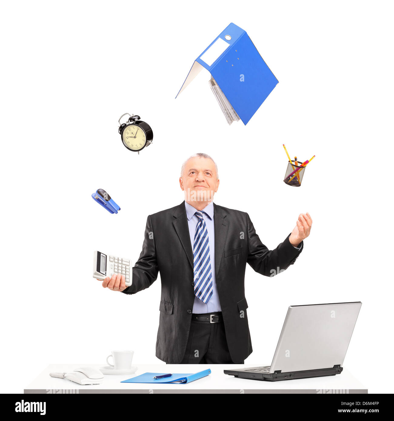 Mature businessman juggling in his office, isolated on white background ...