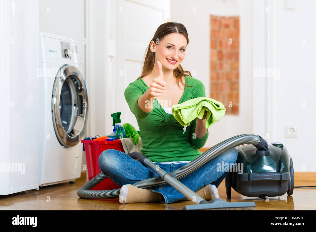 Young woman cleaning at home, she has a cleaning day and using a vacuum ...
