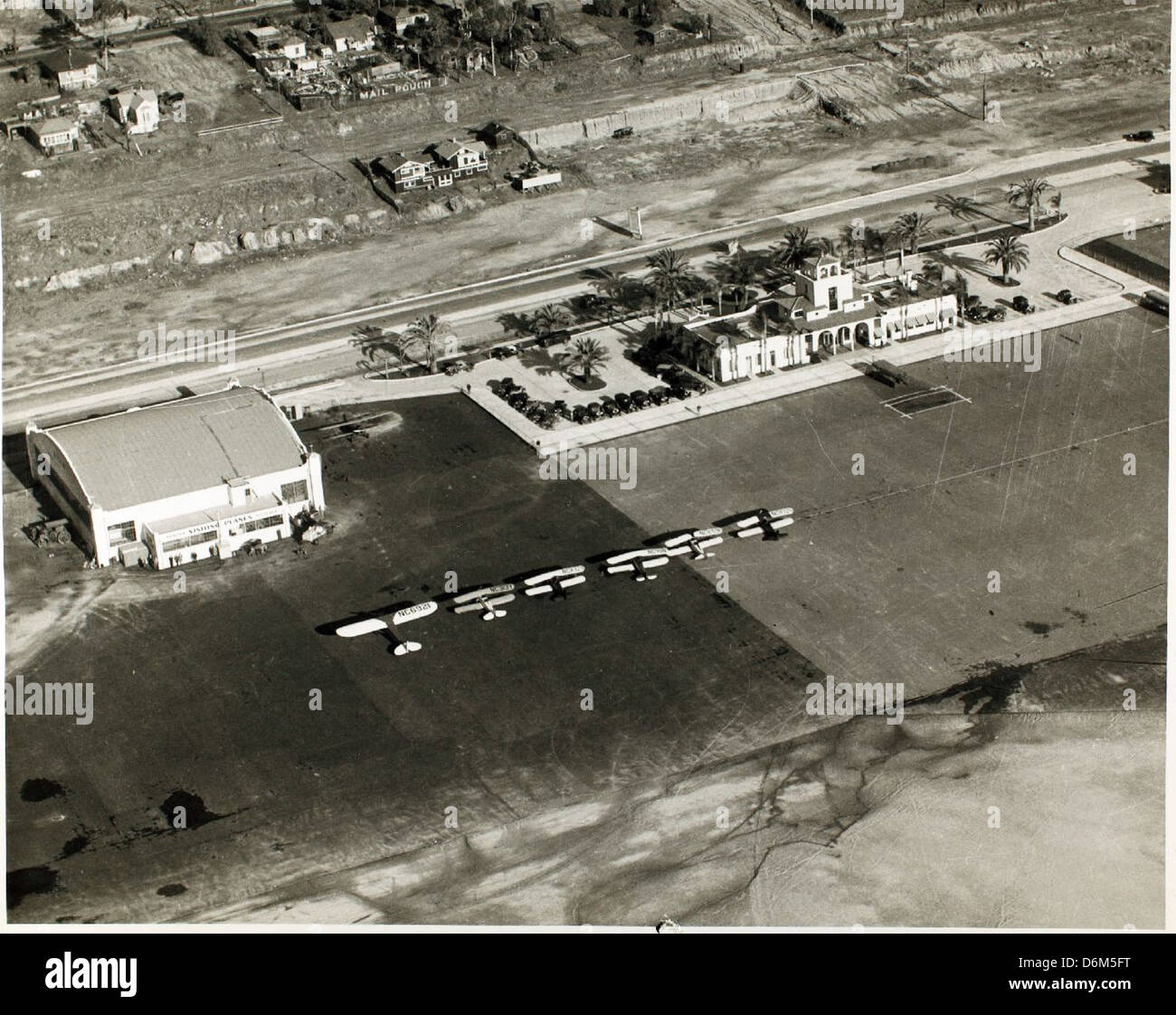 This 1932 photograph captures a plane in flight over an airfield ...