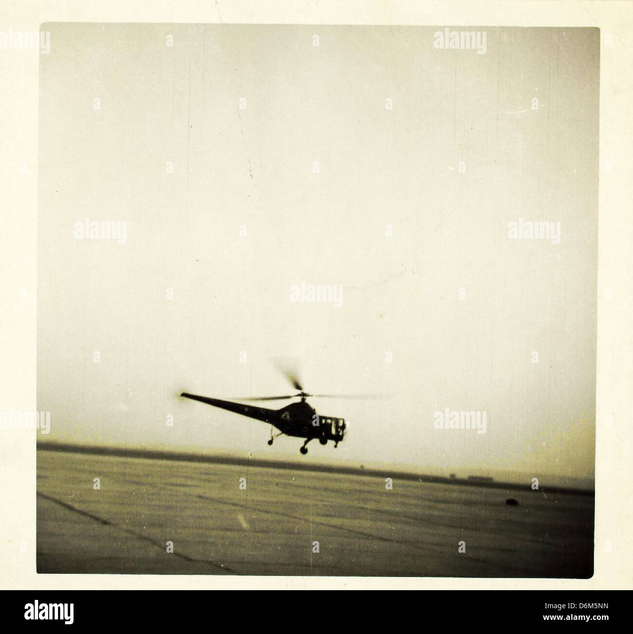 A historical photograph showing a helicopter landing, emphasizing the ...