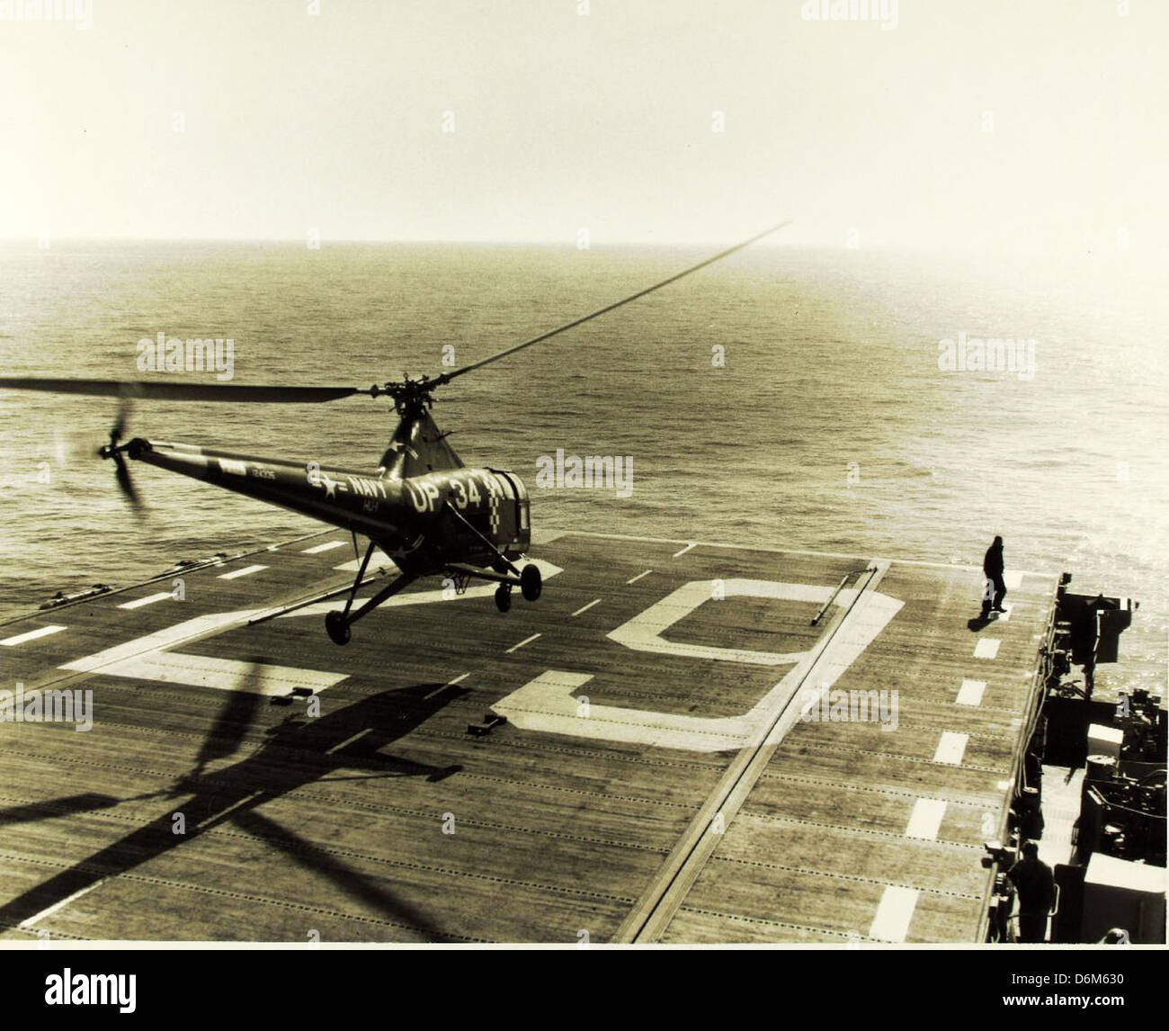 This photo captures the HO3 HU-1 helicopter taking off from a ship. The ...