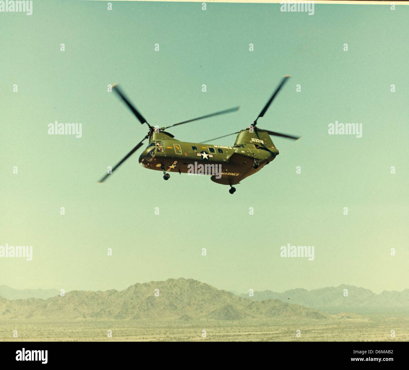 The H-46 helicopter is shown in flight above a desert landscape in this ...