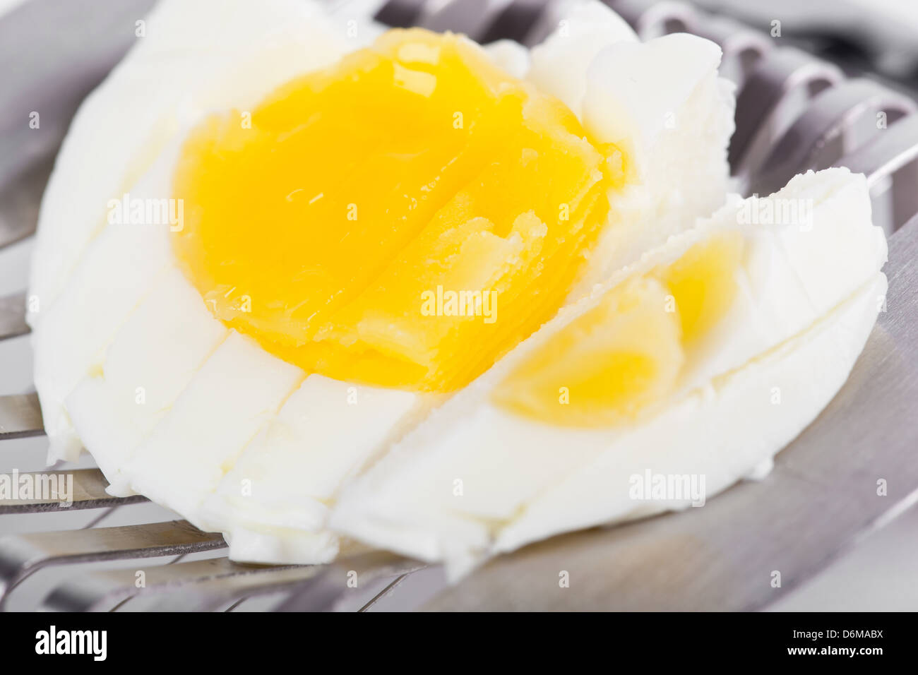 Half egg on cutter, closeup on white Stock Photo - Alamy