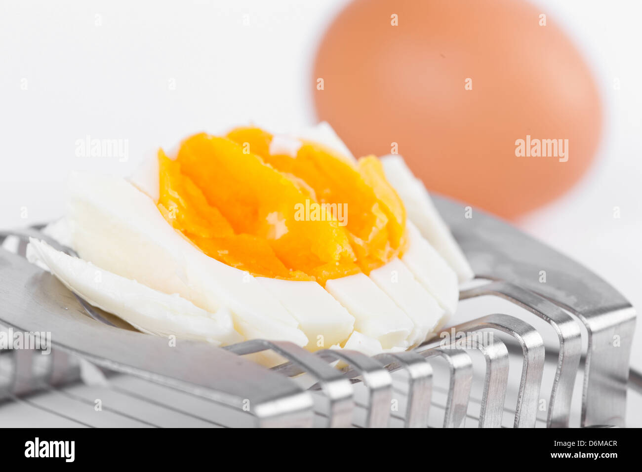 Cutted egg on cutter, closeup on white Stock Photo - Alamy