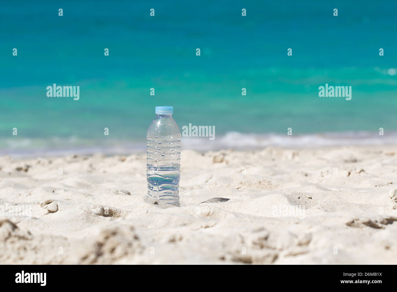 Drinking water in bottle on sand on beach Stock Photo - Alamy