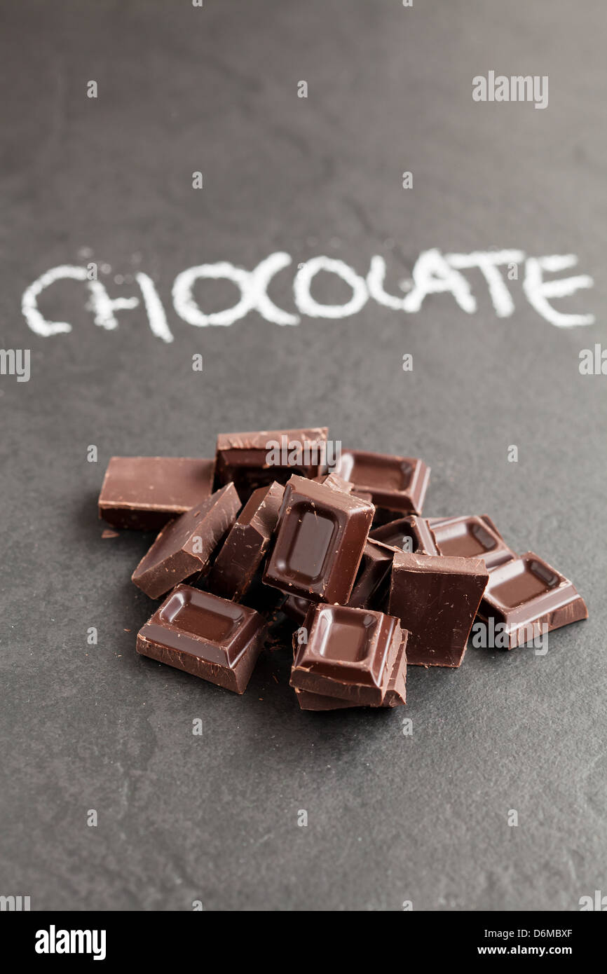 Closeup of pile of chocolate squares with word chocolate written in ...