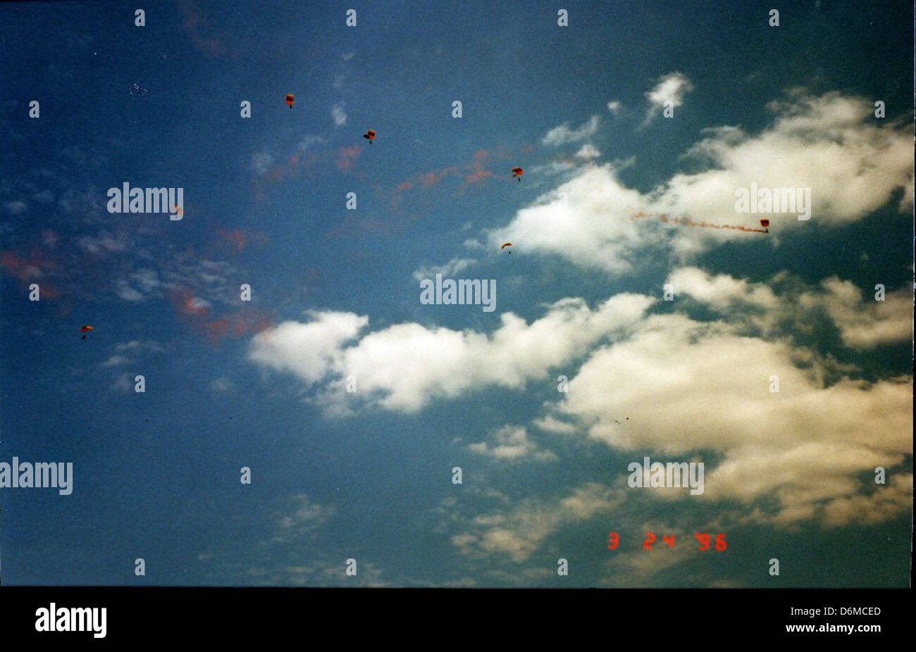 This 1996 photograph captures parachutists in action during a skydiving ...