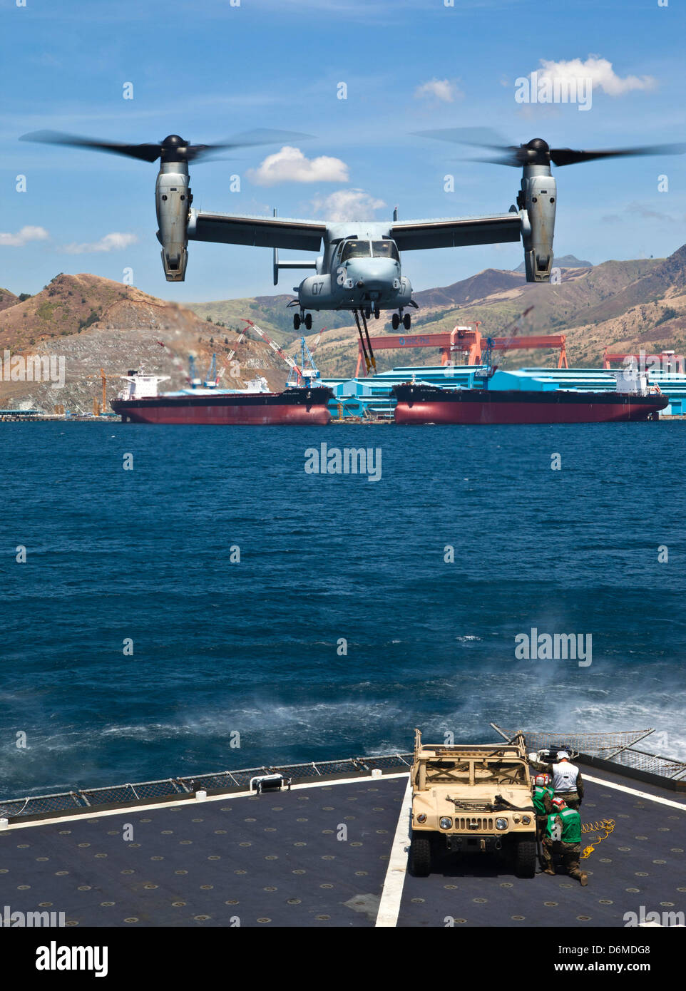 A US Marine Corps MV-22B Osprey prepares to lift a Humvee jeep from the ...
