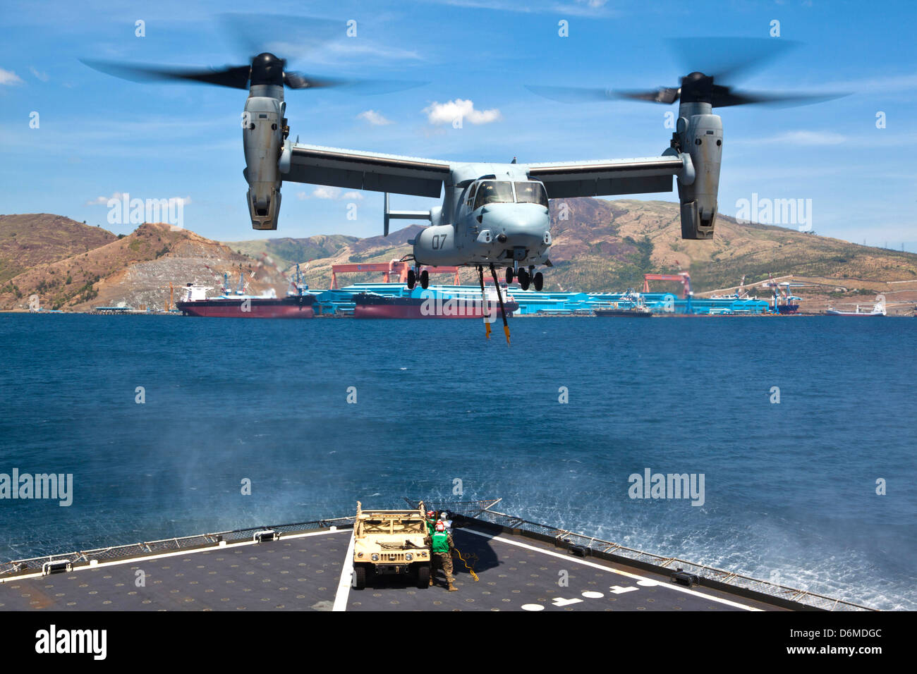 A US Marine Corps MV-22B Osprey prepares to lift a Humvee jeep from the ...