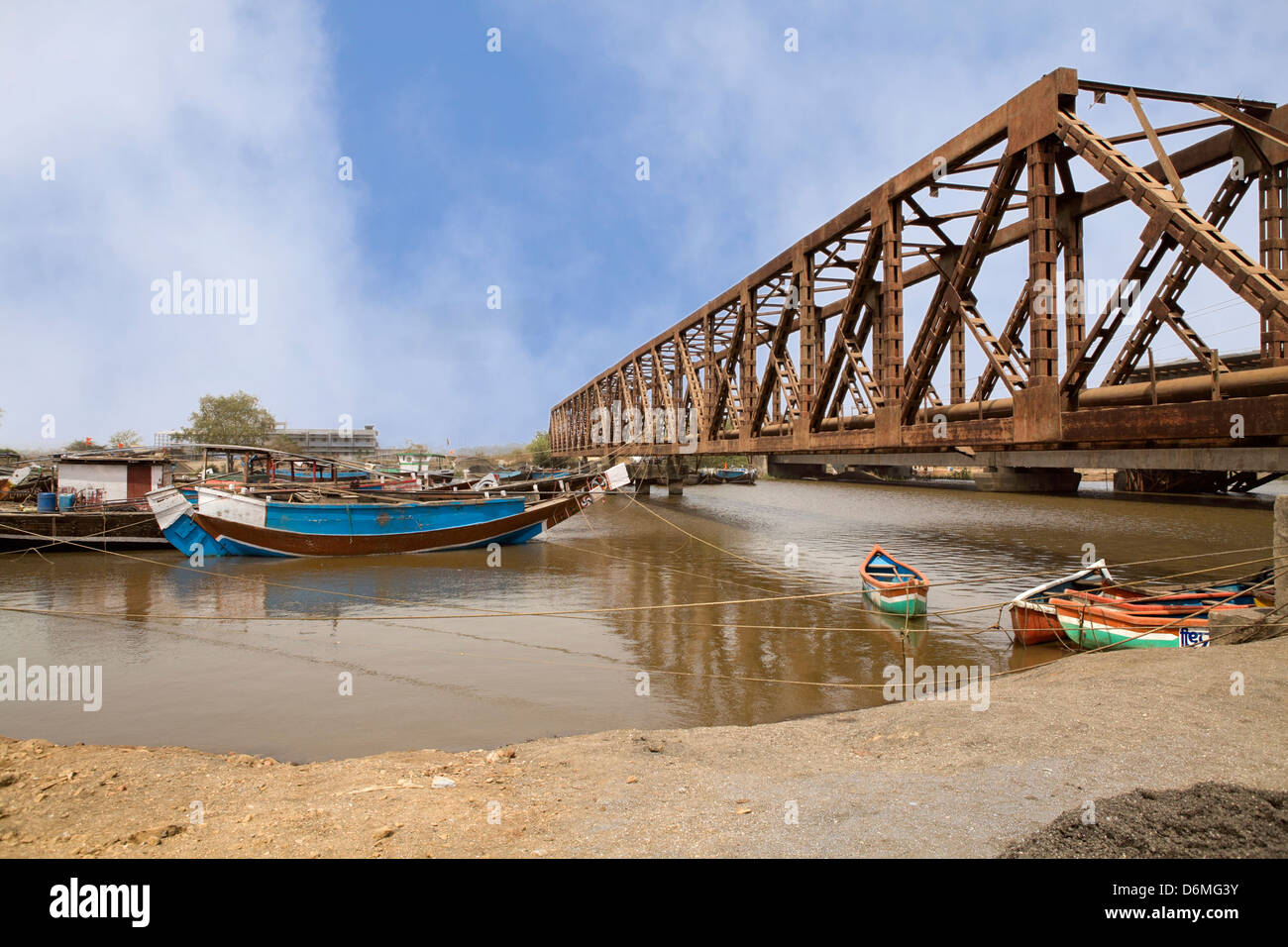 A metal bridge on a river with anchored boats Stock Photo - Alamy