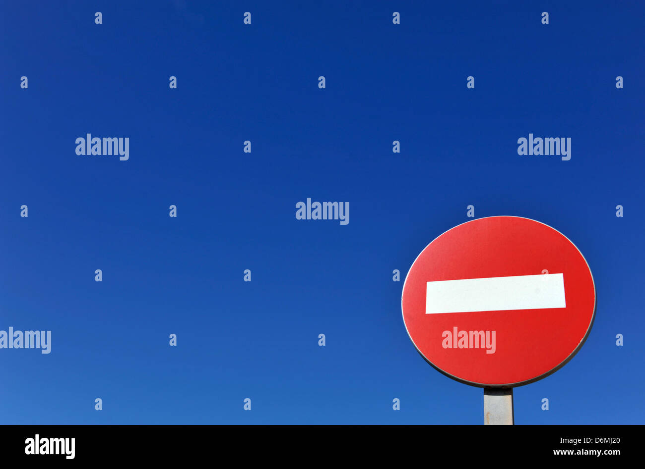 A photograph of a red and white no entry road sign with a clear blue ...