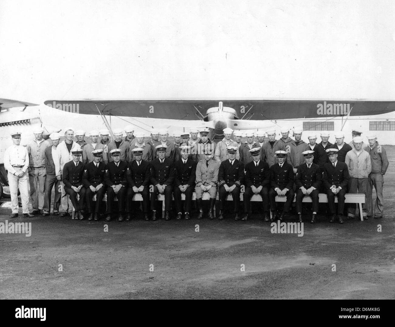 A group photo captures individuals and aviation personnel in a historic ...