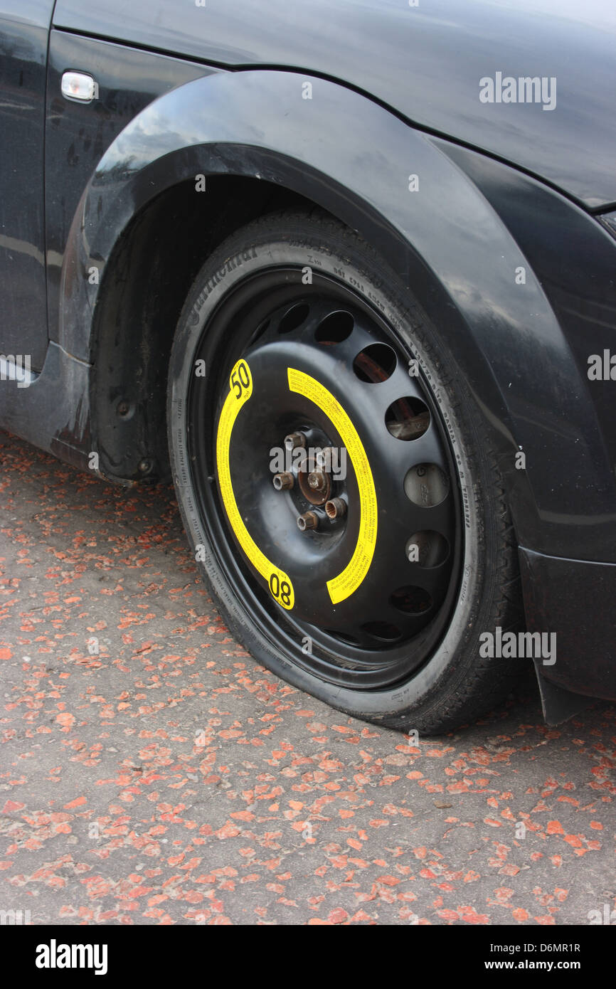 Abandoned car with punctured space-saver spare wheel Stock Photo - Alamy