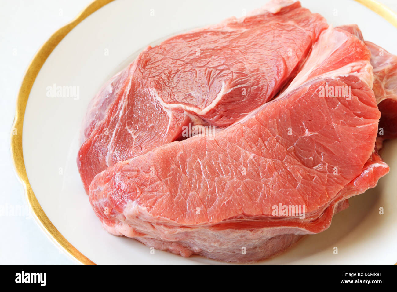 Good lean cut of raw beef on china ware Stock Photo - Alamy