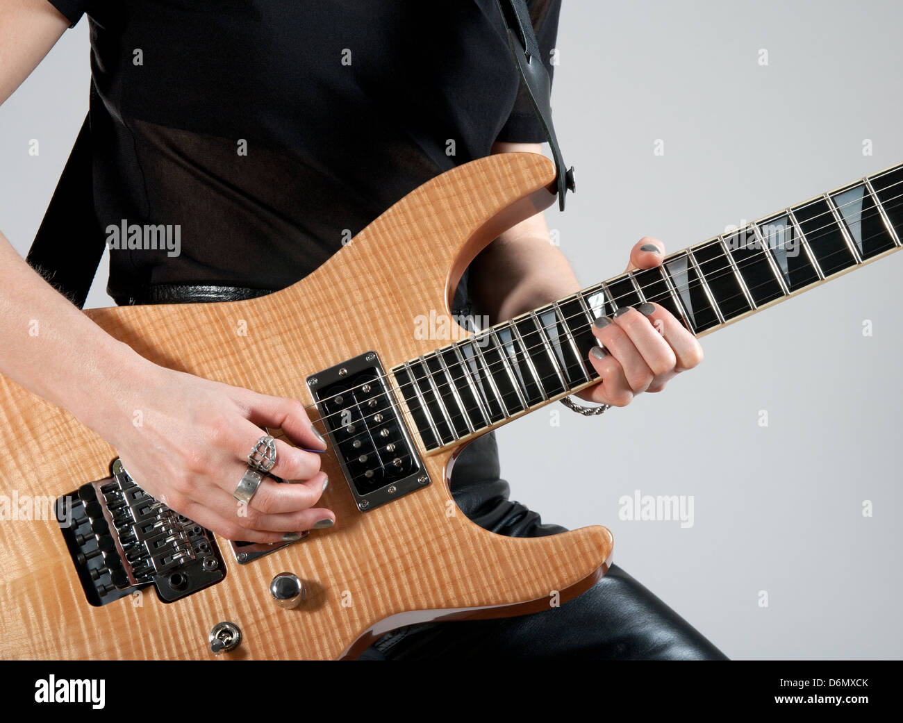 Female guitarist playing hard rock style electric guitar Stock Photo ...
