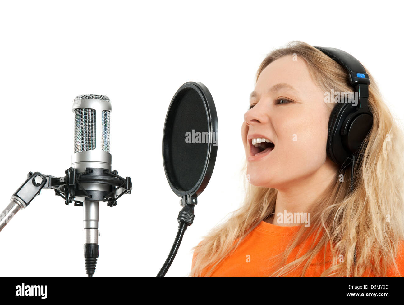 Female singer in headphones singing with studio microphone. Isolated on ...