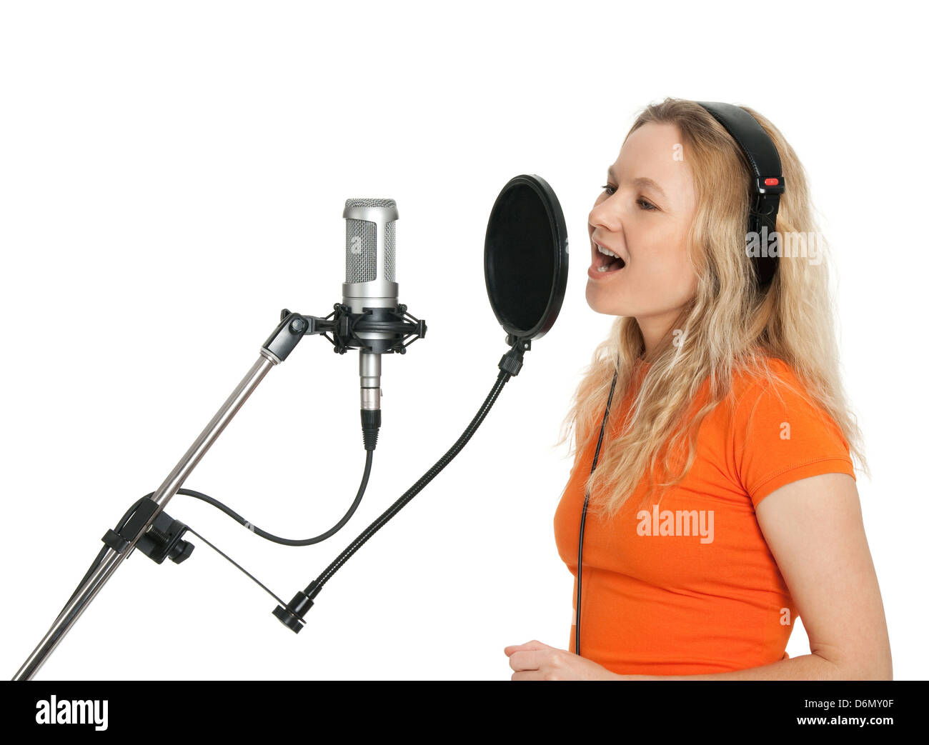 Female singer in orange t-shirt singing with studio microphone ...