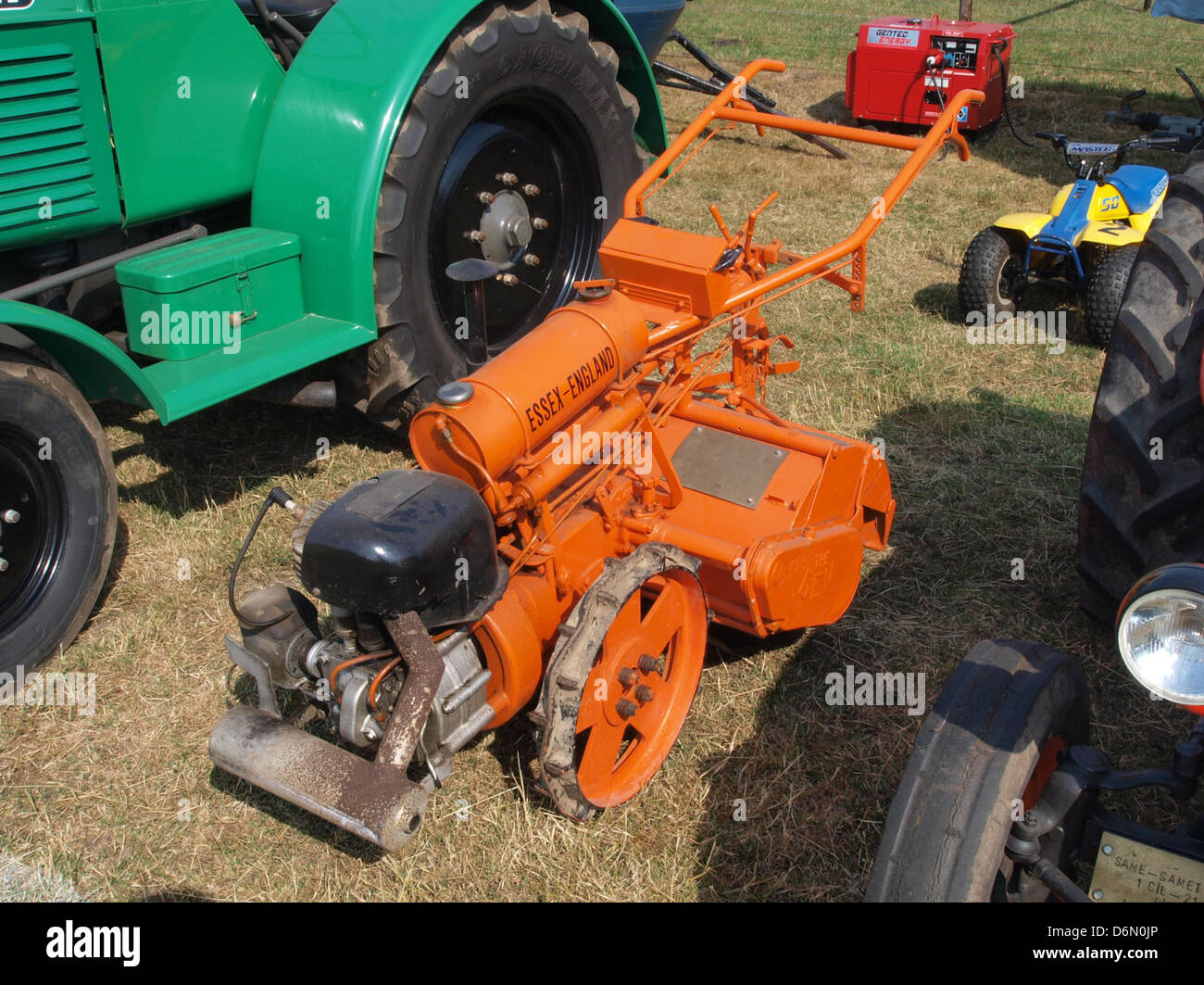 This old orange tractor, likely from the mid-20th century, represents ...