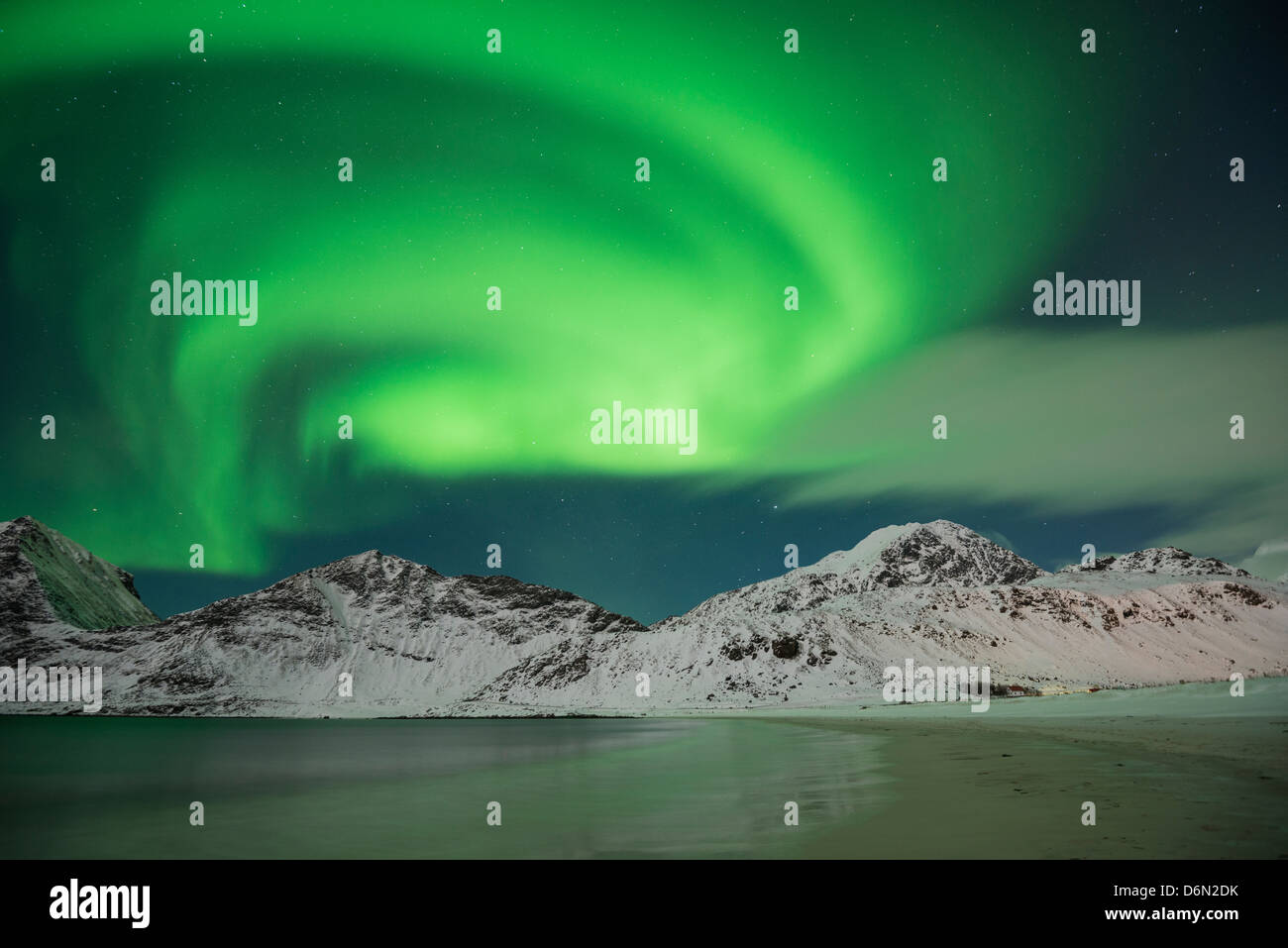 Northern lights over the sea and snow covered mountains hi-res stock ...