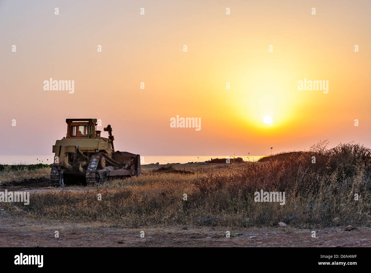 Bulldozer on the beach at sunset Stock Photo - Alamy