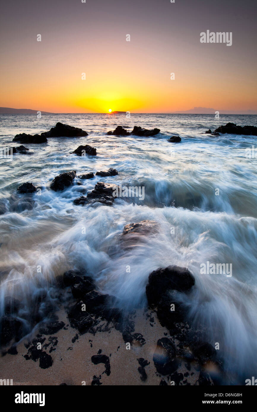 sunset and waves over lava rocks at Oneloa beach or "Big" Beach in ...