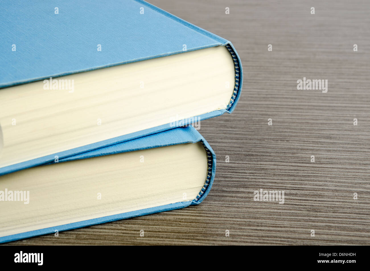 Two blue books on a table with wooden texture Stock Photo - Alamy