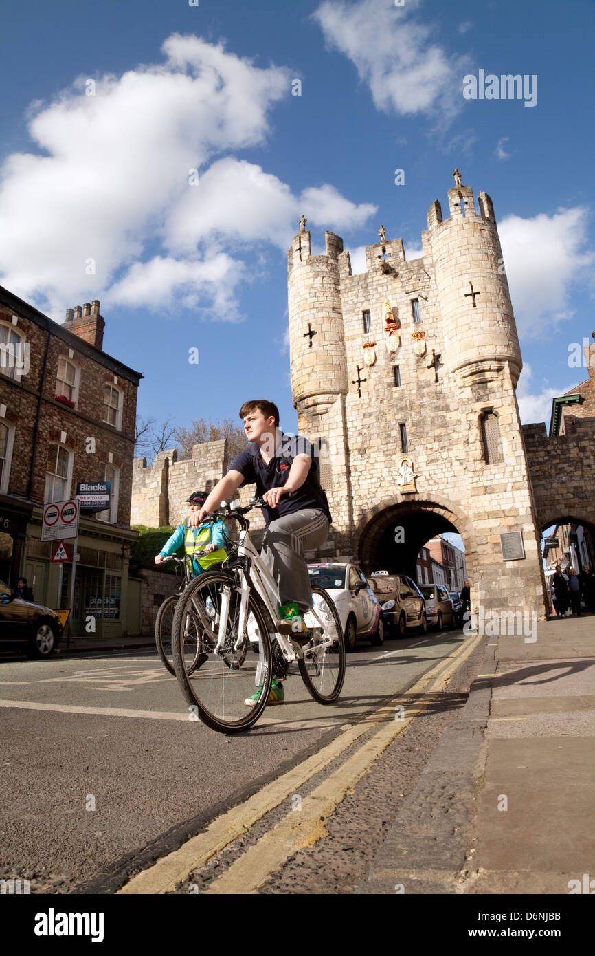 York street scene with Micklegate bar, old York city walls and cyclists ...