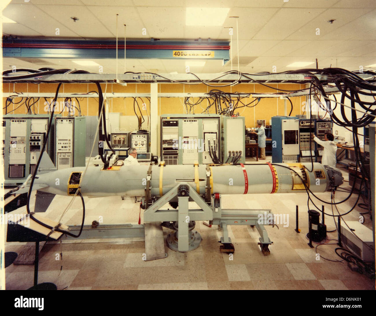 This photograph depicts personnel working on the Tomahawk missile ...