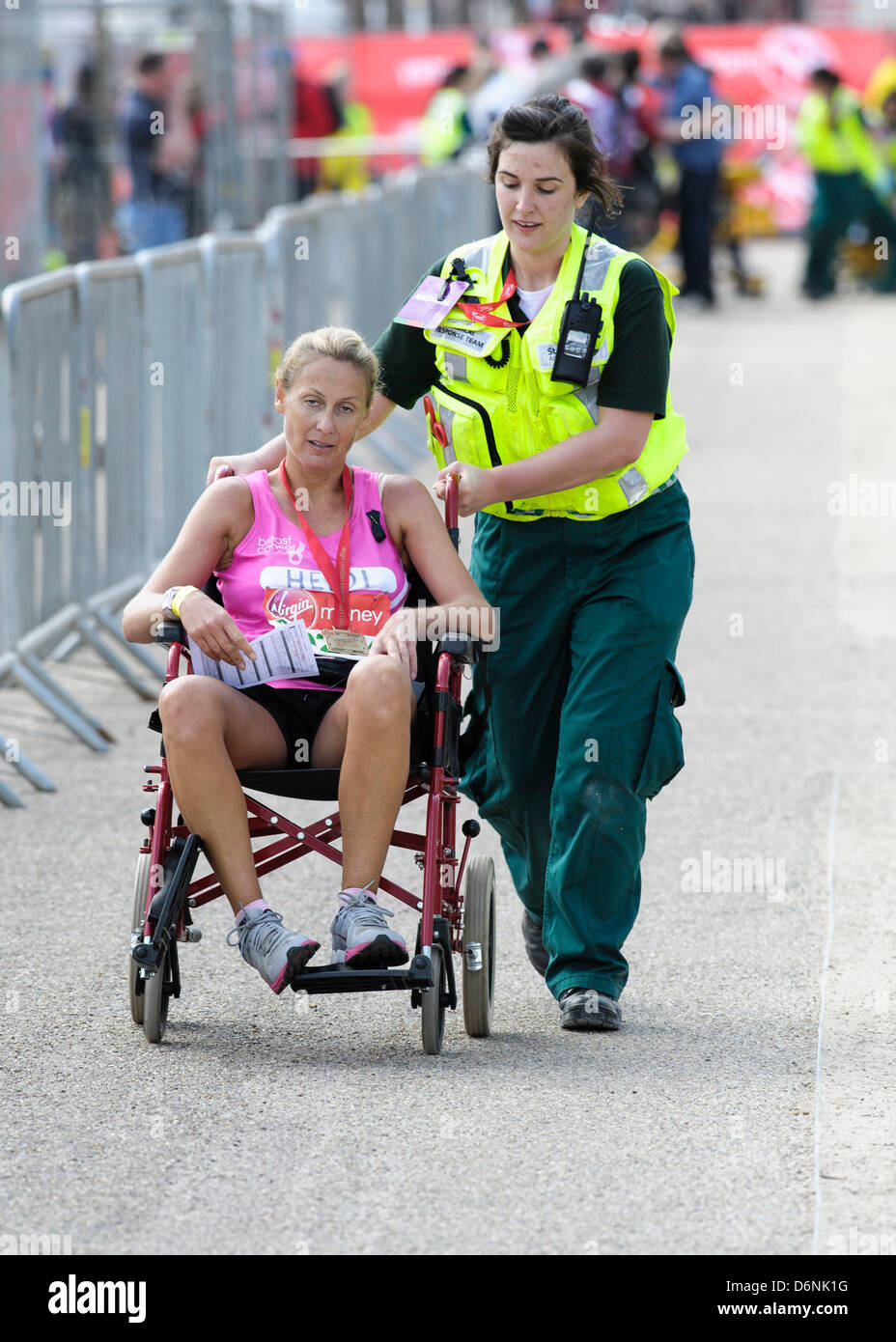 A runner is helped away in a pushchair after finishing the Virgin ...