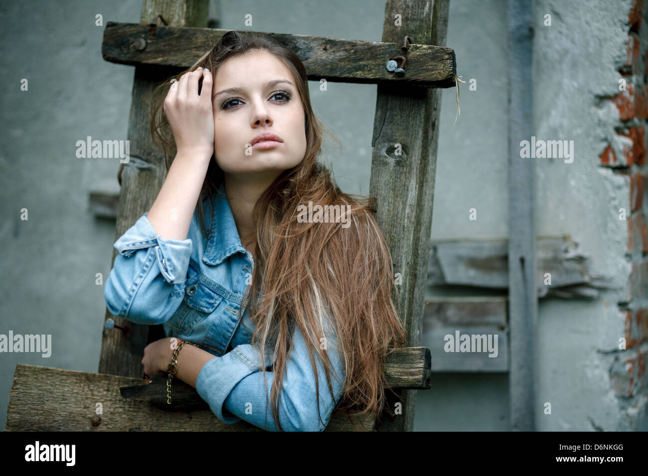 young female wearing jean jacket outdoors with messy hair looking ...