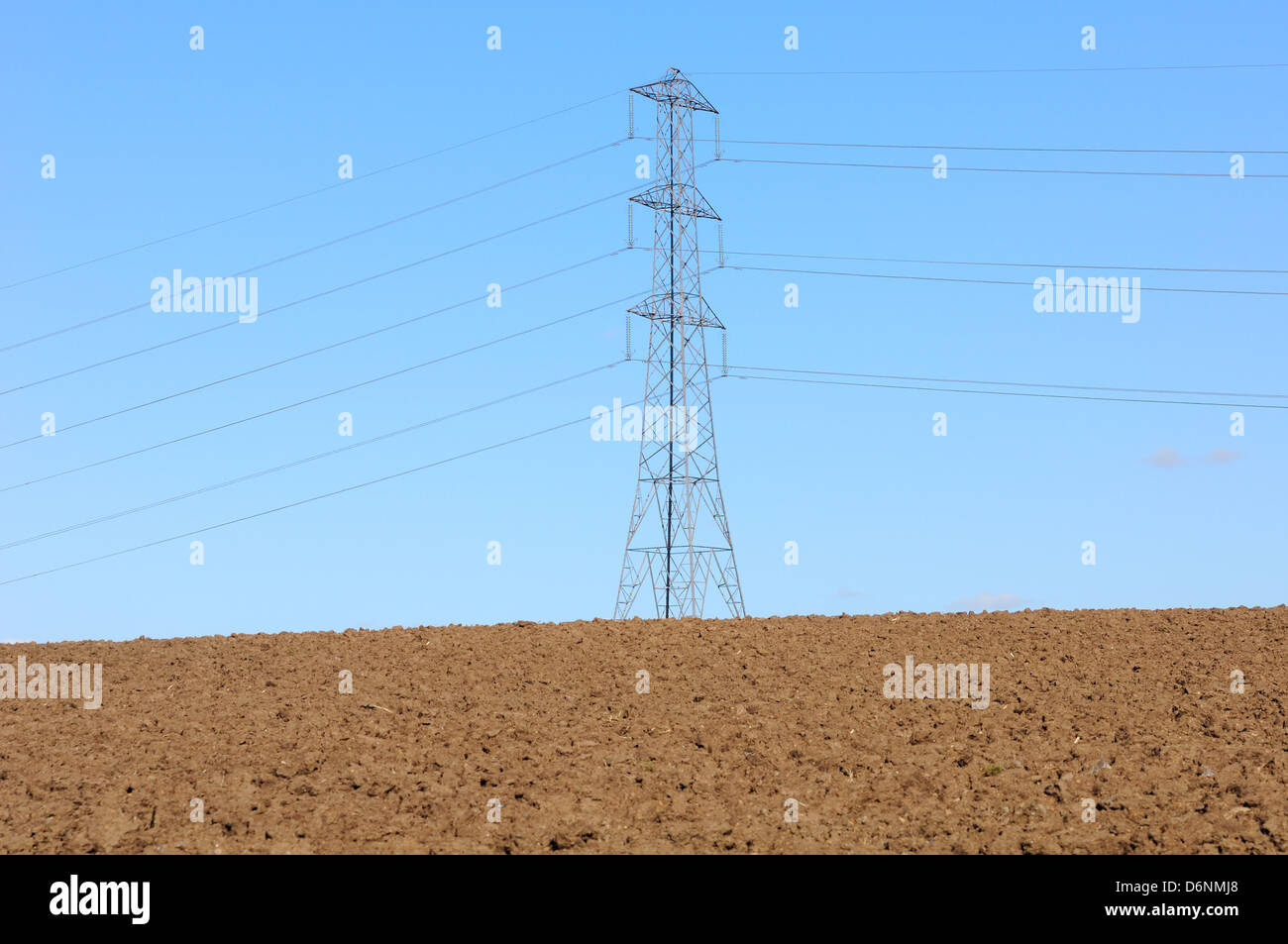 Single pylon in a ploughed field Stock Photo - Alamy