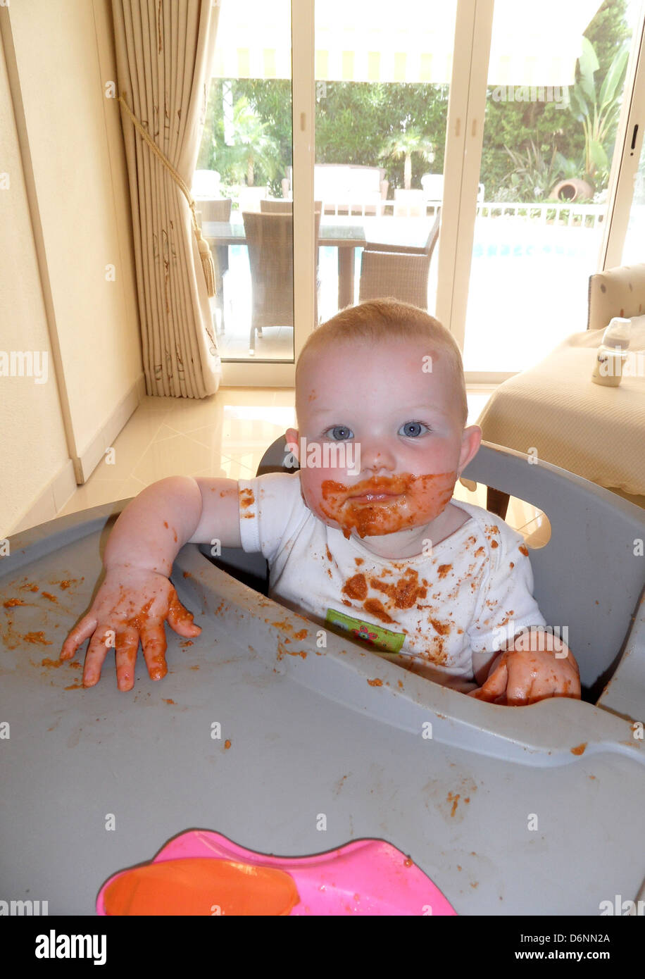 Baby covered in food after eating Stock Photo - Alamy