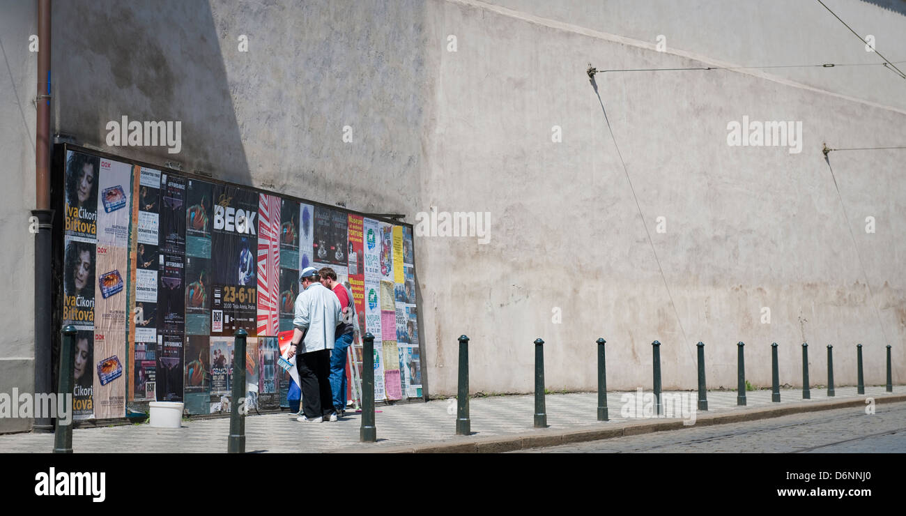 Men putting poster on a wall, Prague Stock Photo - Alamy