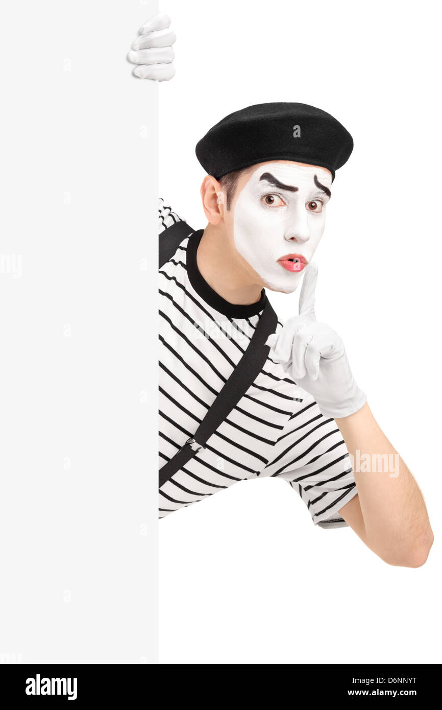 Male mime artist holding a blank panel and gesturing silence with a ...
