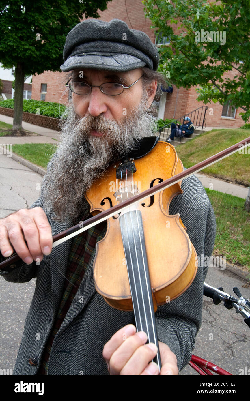 Older gentleman with long gray beard playing fiddle on the street ...
