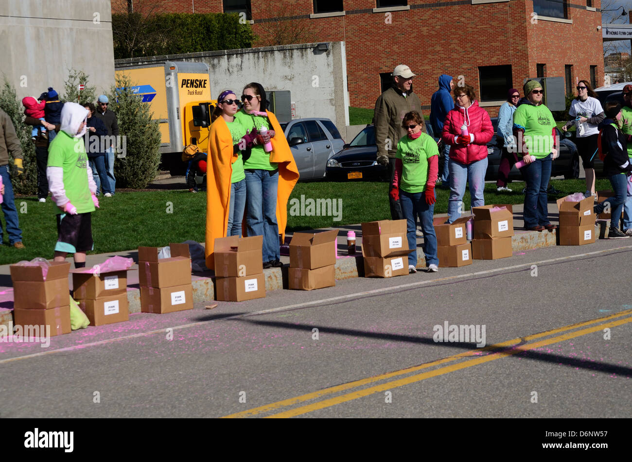 Costumed race staff prepare to spray color on runners at start of race ...