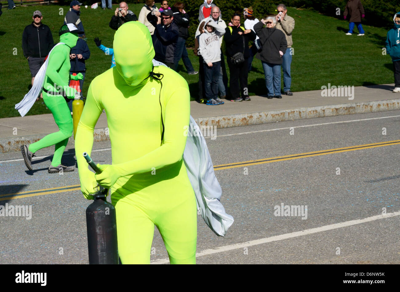 Costumed race staff prepare to spray color on runners at start of race ...