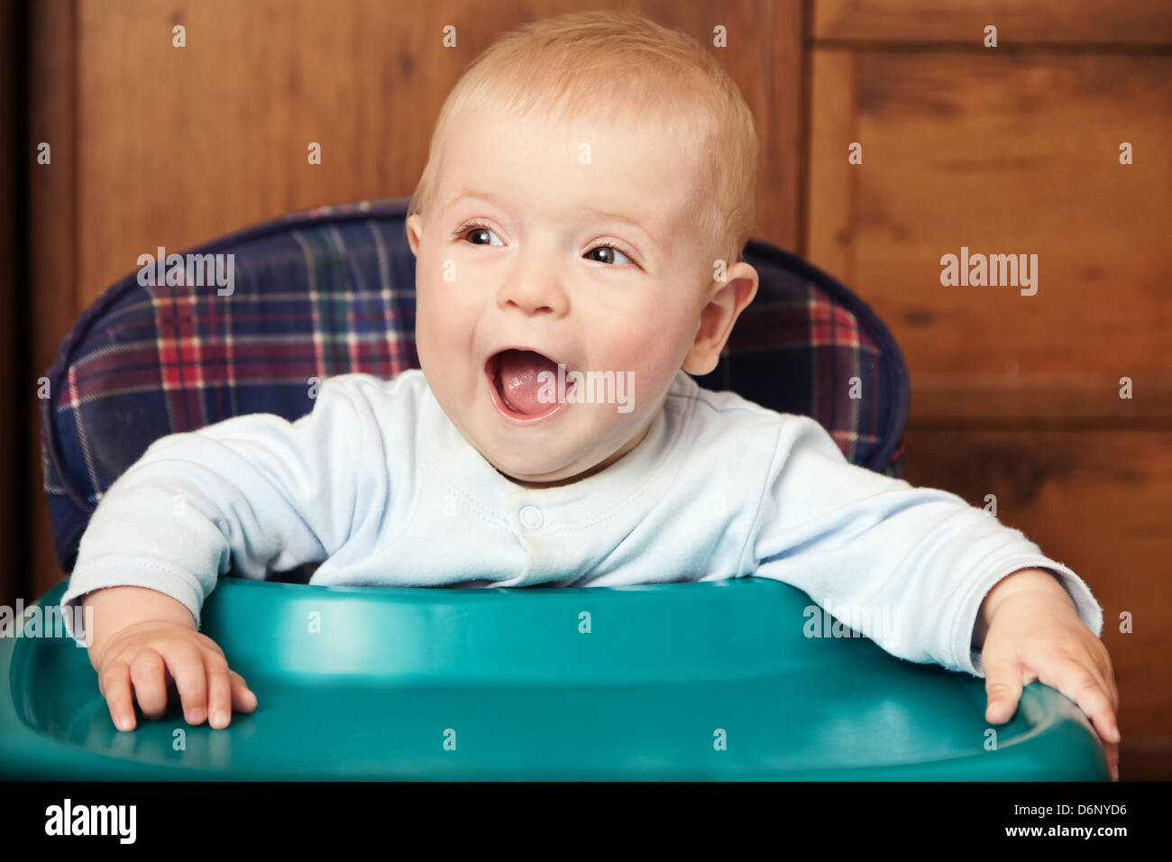 baby laughing, sitting on a chair Stock Photo - Alamy