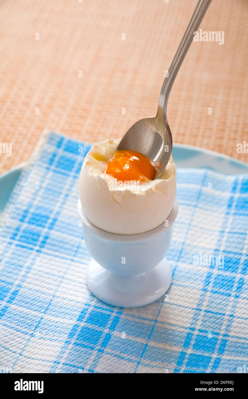 Soft boiled egg in an egg cup with spoon. Close view Stock Photo - Alamy