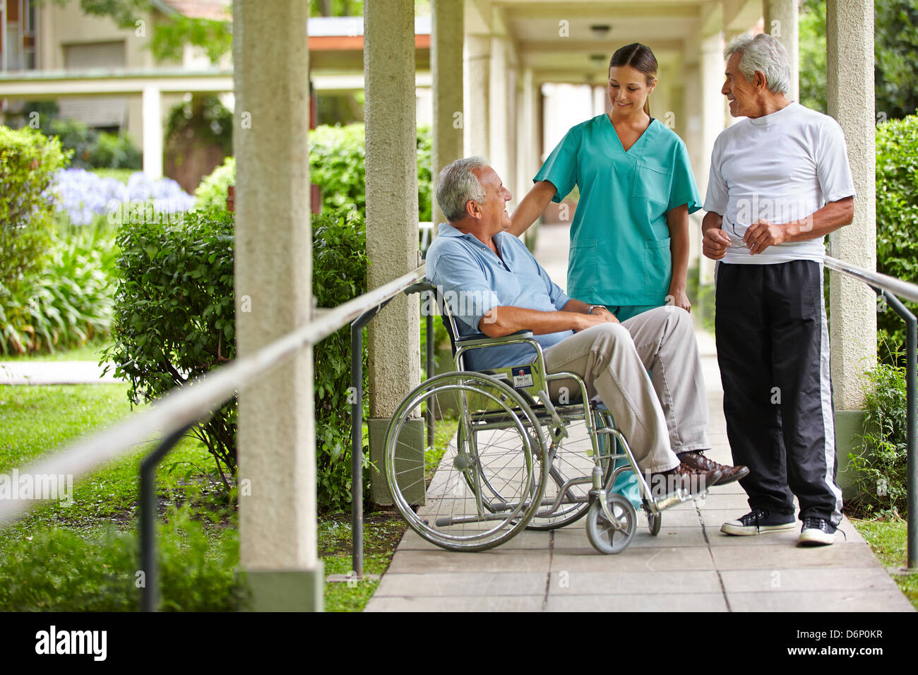 Two senior citizens talking to a nurse in a hospital garden Stock Photo ...