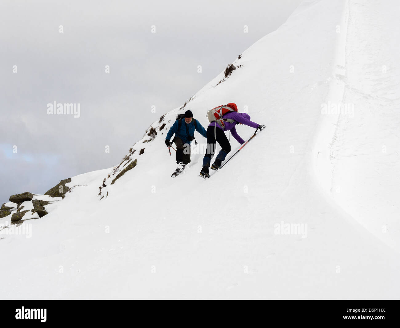 Two people walking down a deep snowdrift on Tal-y-Fan mountain in ...