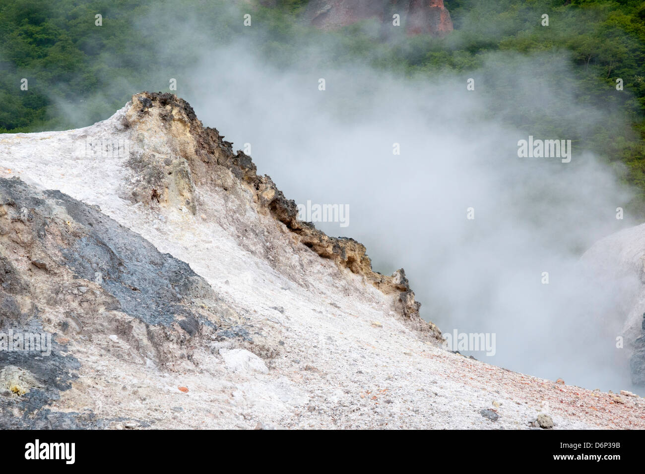 colorful volcanic land with hot steam behind colorful mineral sands ...
