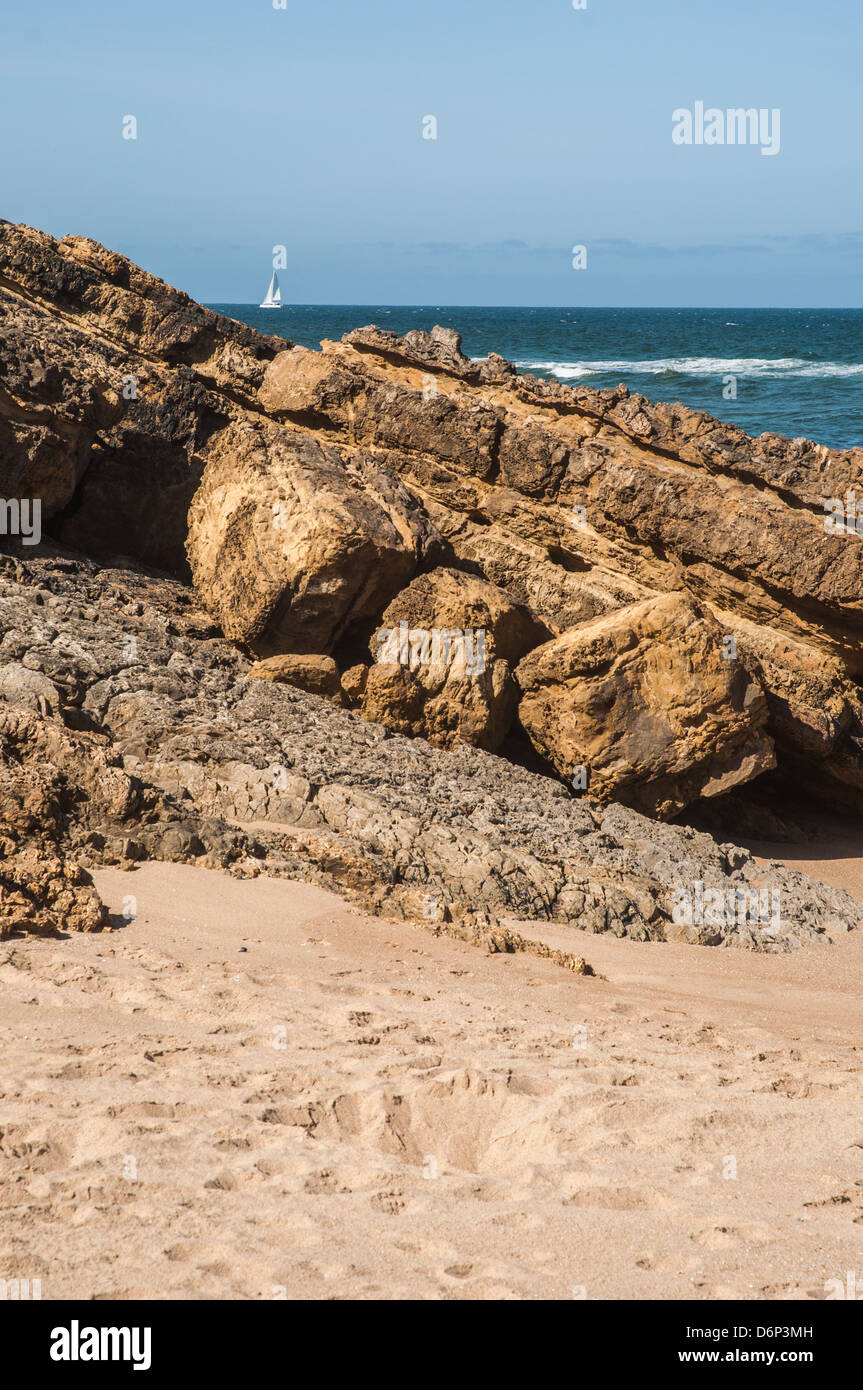 Big rock laying on a sandy beach with bright blue sky Stock Photo - Alamy